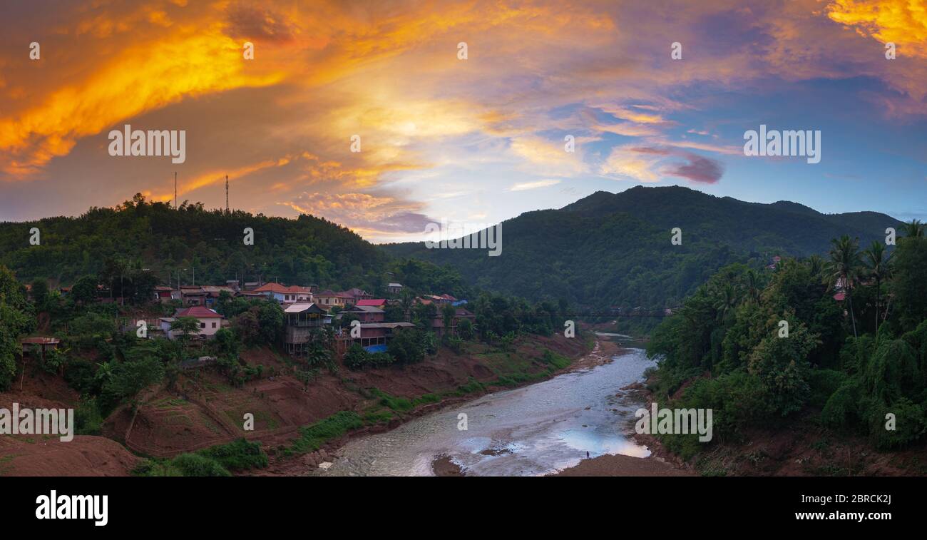 Muang Khua village in the mountains of North Laos, sunset dramatic sky ...