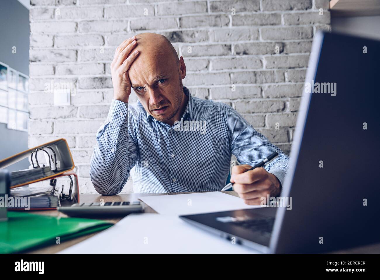 Finacial problems and crisis. Stressed depressed man reading bills and ...