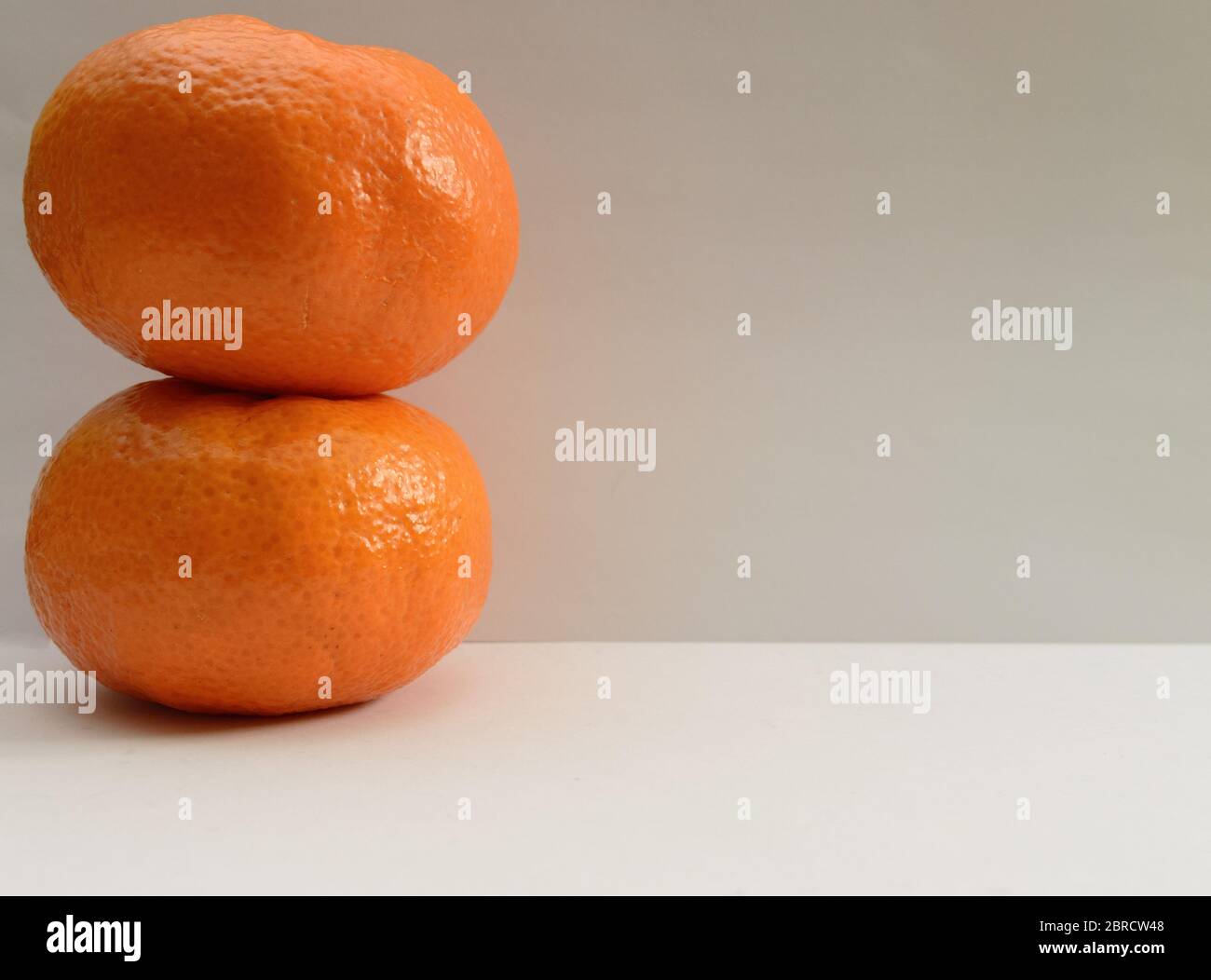 Two Tangerines On Top Of Each Other On White Background Stock Photo - Alamy