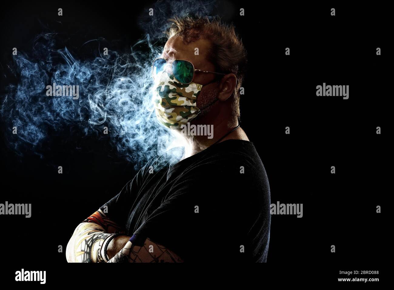 Man with face mask smoking cigarette, Corona series, Germany Stock ...
