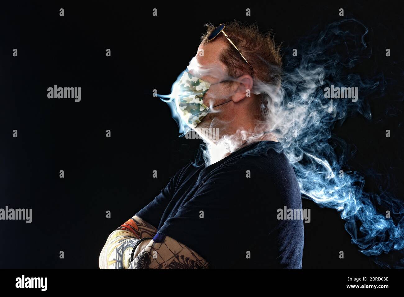 Man with face mask smoking cigarette, Corona series, Germany Stock ...