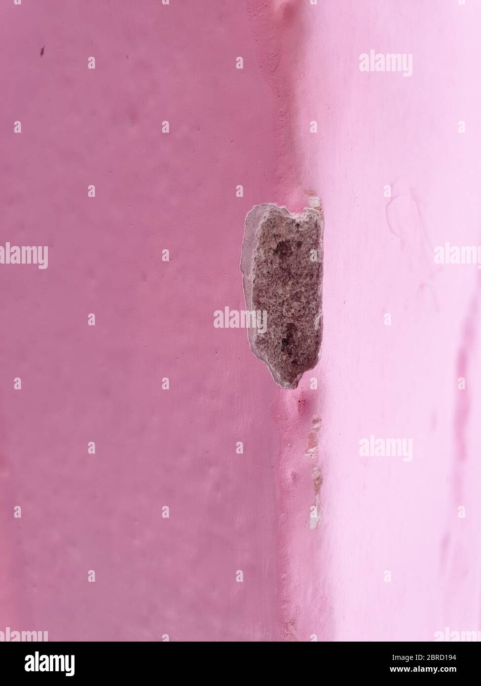 Wall scratch.A patch on cemented wall with pink colour. Need repair ...