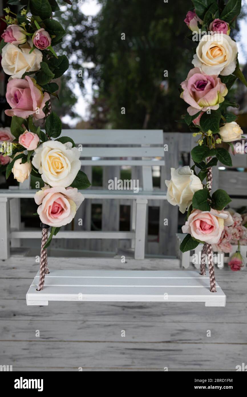 Wedding swing decorated with rose flowers hanging Stock Photo - Alamy