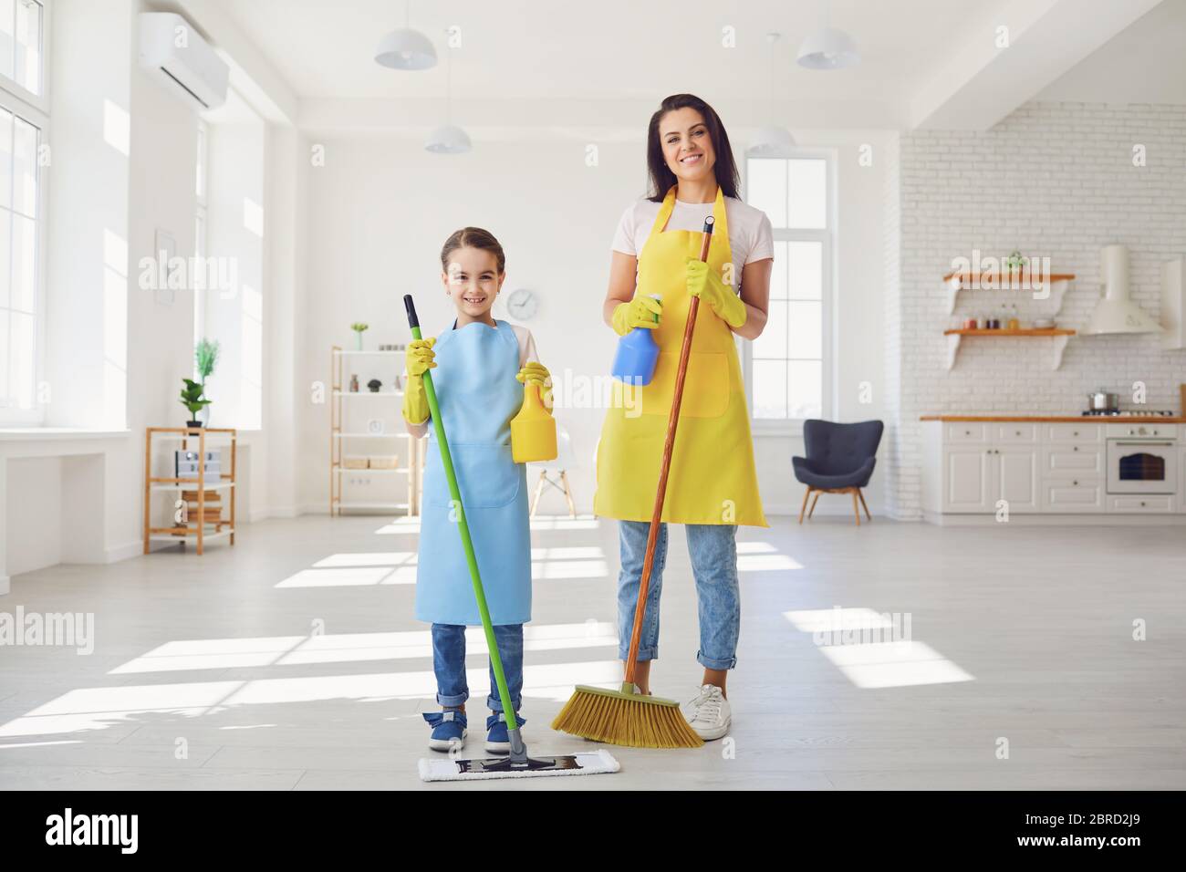 Happy family cleans the room in the house. Mother and kid clean the ...
