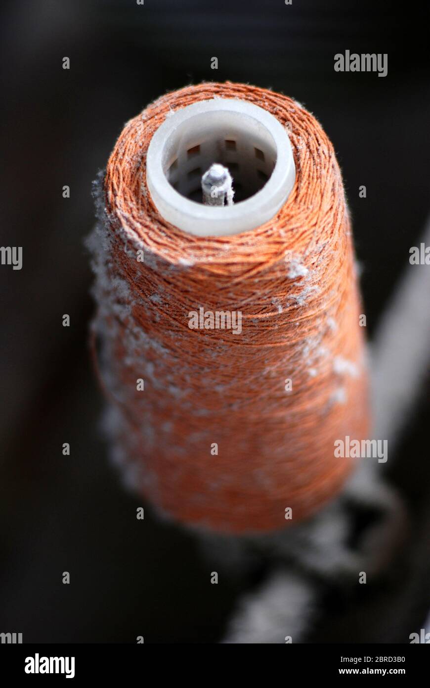 Textile spool of orange color full of dust Stock Photo - Alamy