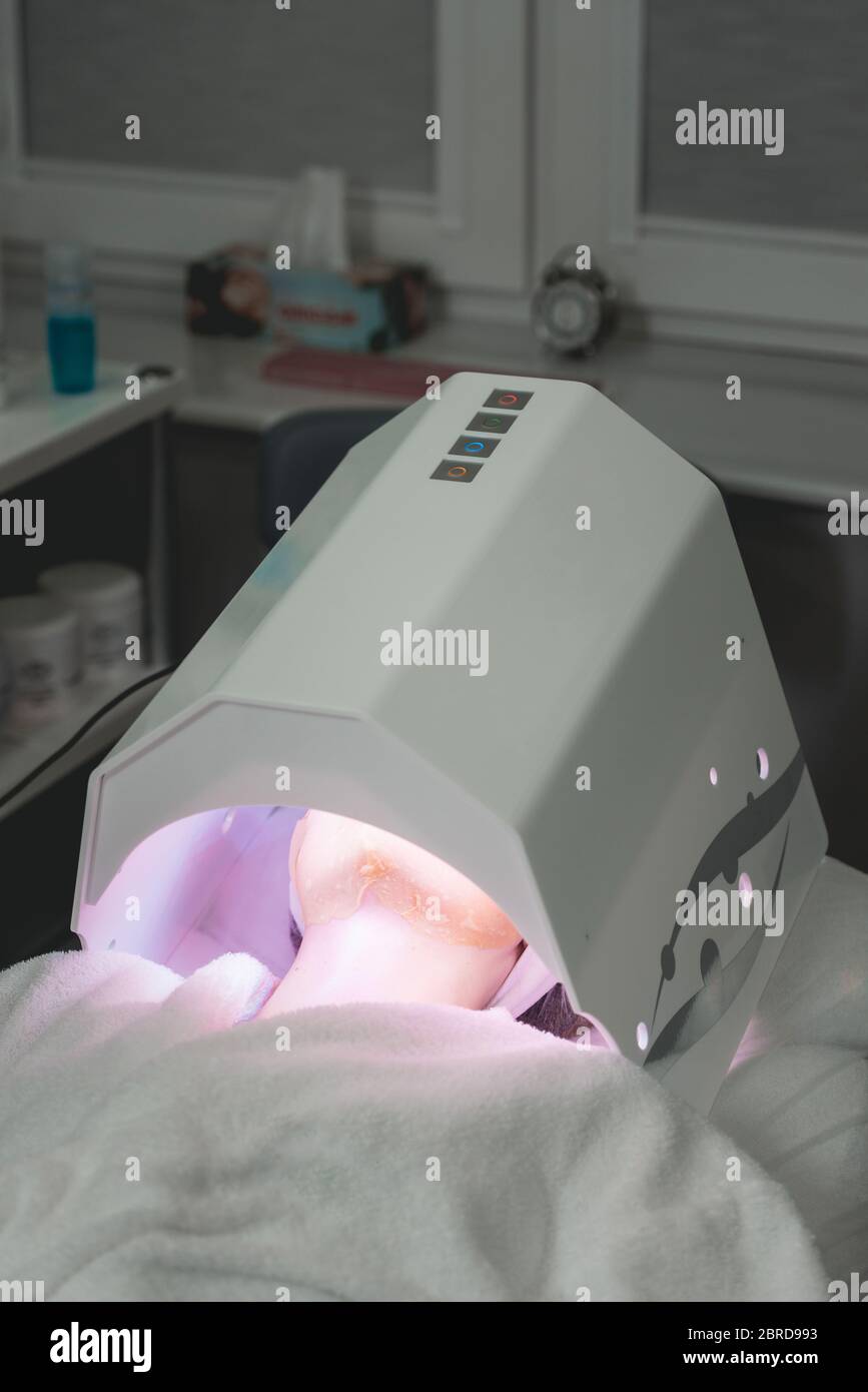 Patient under special light healing lamp Stock Photo - Alamy