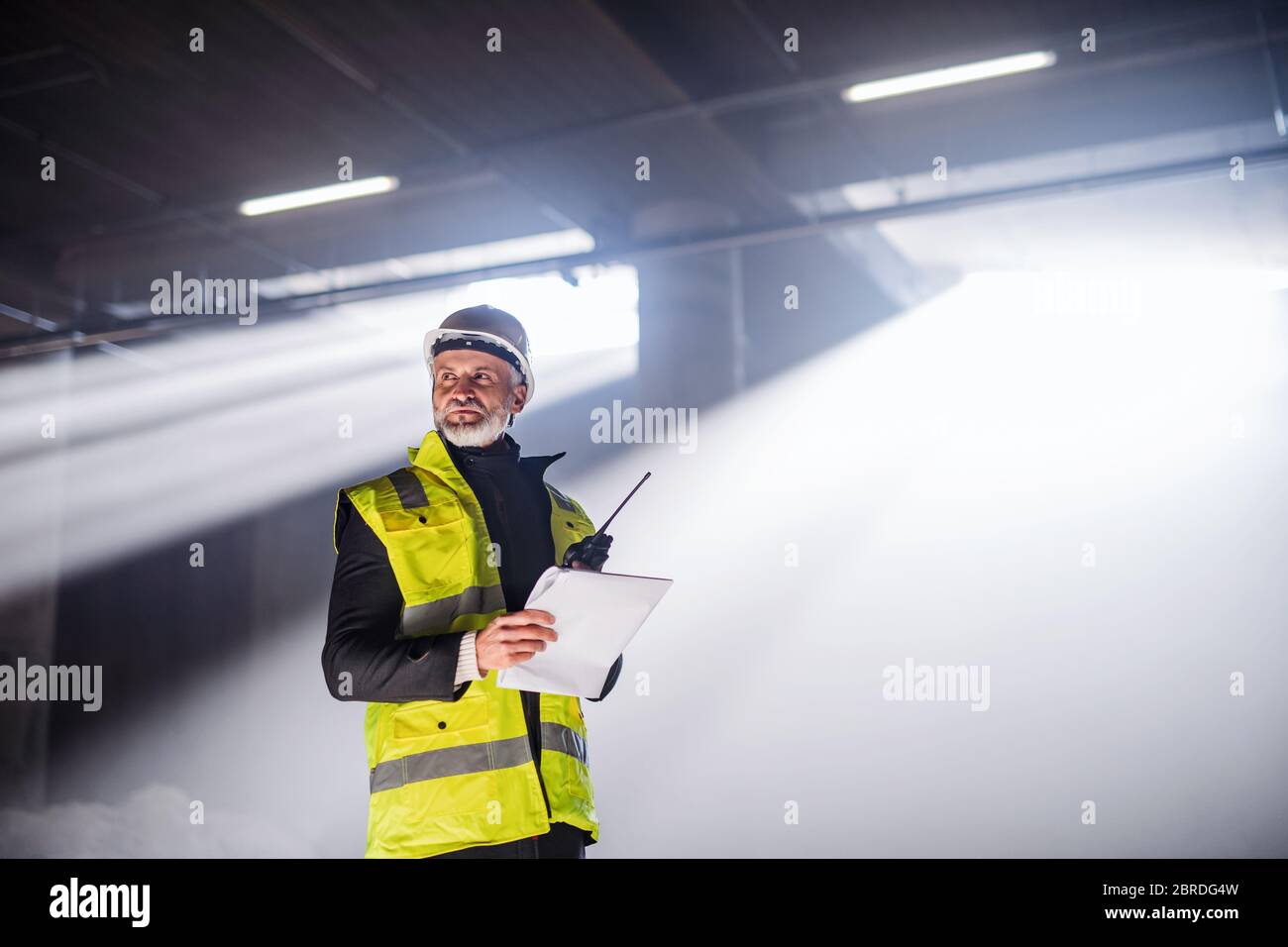 Man engineer using walkie talkie on construction site Stock Photo - Alamy