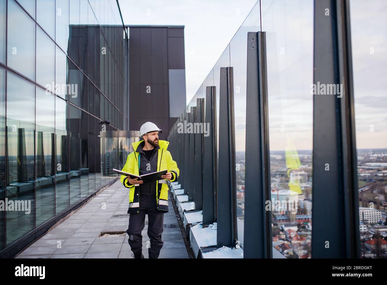 Man engineer walking on construction site, holding blueprints Stock ... Man engineer walking on construction site, holding blueprints Stock ...