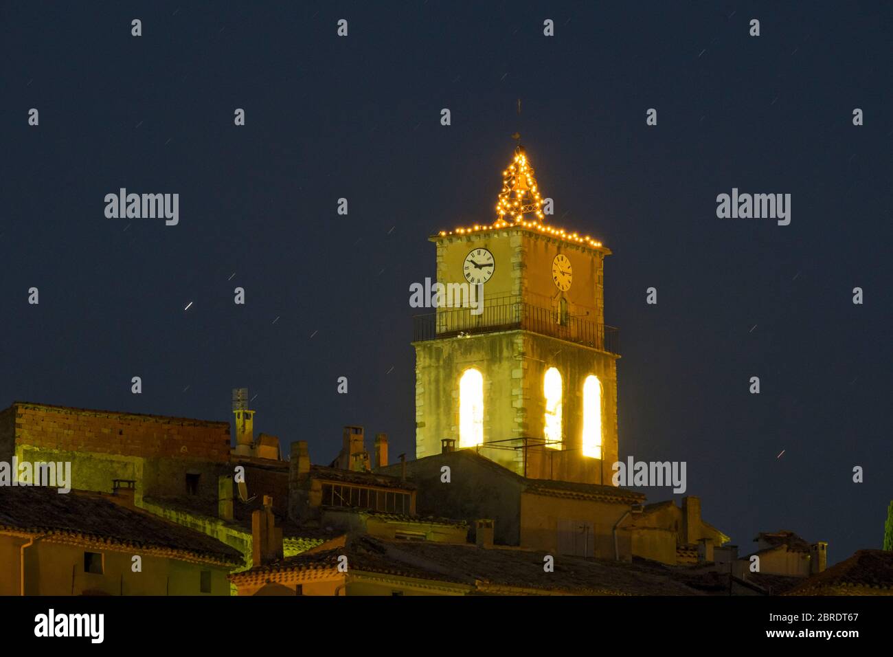 Night view of floodlit clocktower of the church at Sablet village in ...