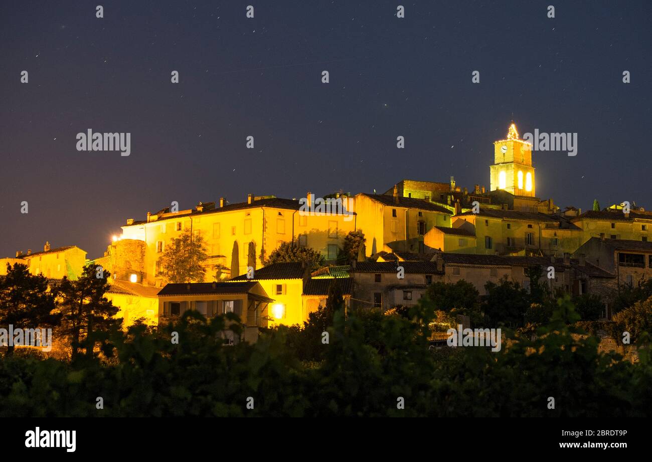 Night view of floodlit clocktower of the church at Sablet village in ...