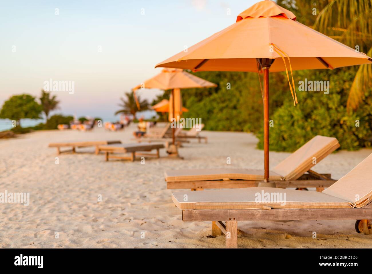 Beautiful sunset beach. Chairs on the sandy beach near the sea. Summer ...