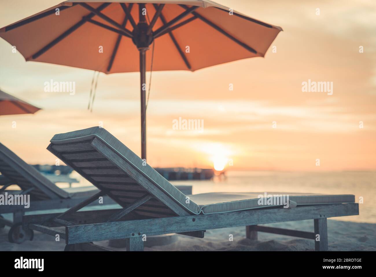 Beautiful sunset beach. Chairs on the sandy beach near the sea. Summer ...