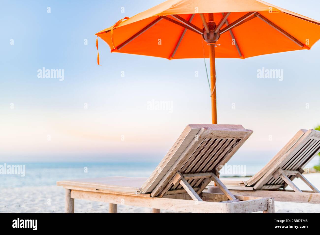 Beautiful sunset beach. Chairs on the sandy beach near the sea. Summer ...