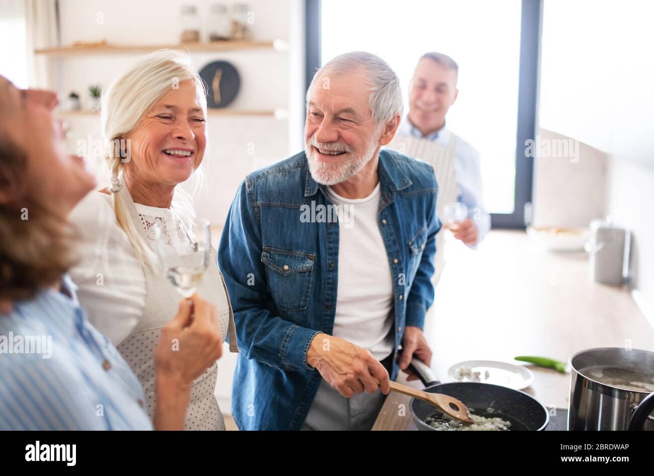 Group of senior friends at dinner party at home, cooking Stock Photo ...