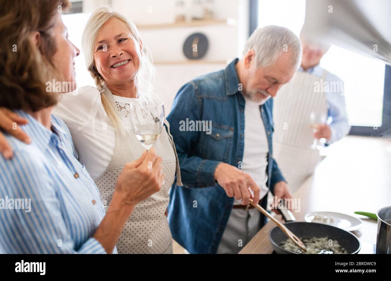 Group of senior friends at dinner party at home, cooking Stock Photo ...