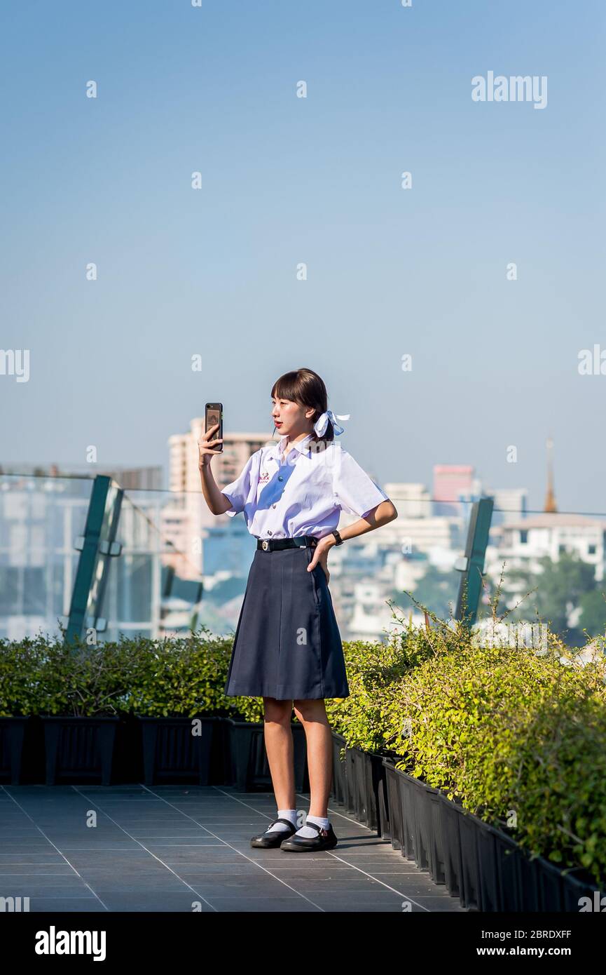 A pretty Thai university student takes a selfie on the balcony of ...