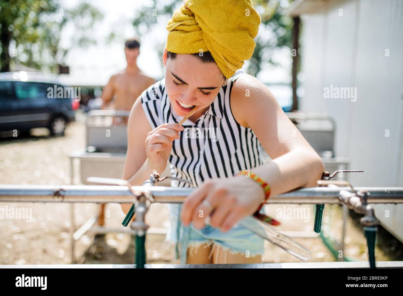 Young woman at summer festival, brushing teeth by basins Stock Photo ...