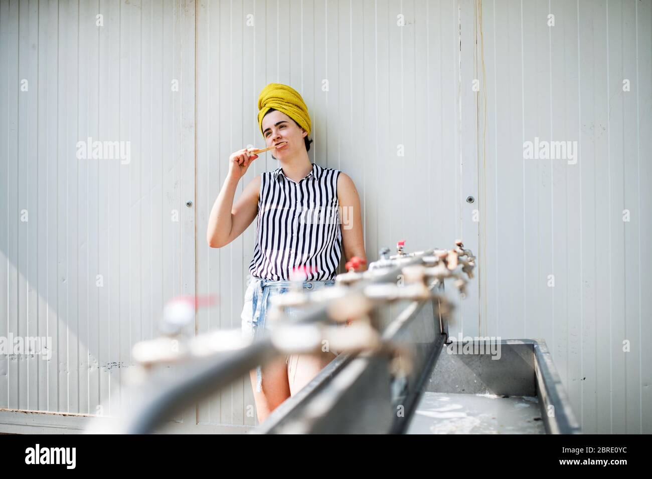 Young woman at summer festival, brushing teeth by basins Stock Photo ...