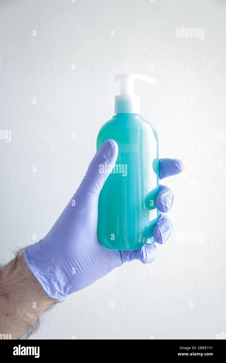 Hand wearing gloves and liquid soap to protect ourselves from covid-19 ...