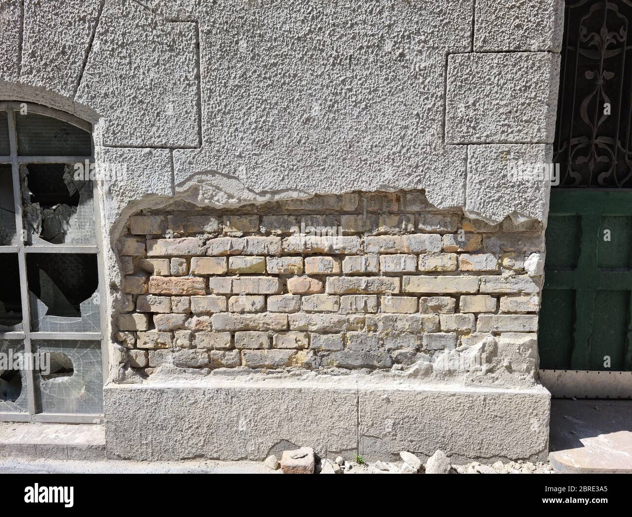 Broken wall with cracked windows in an urban street, construction and ...