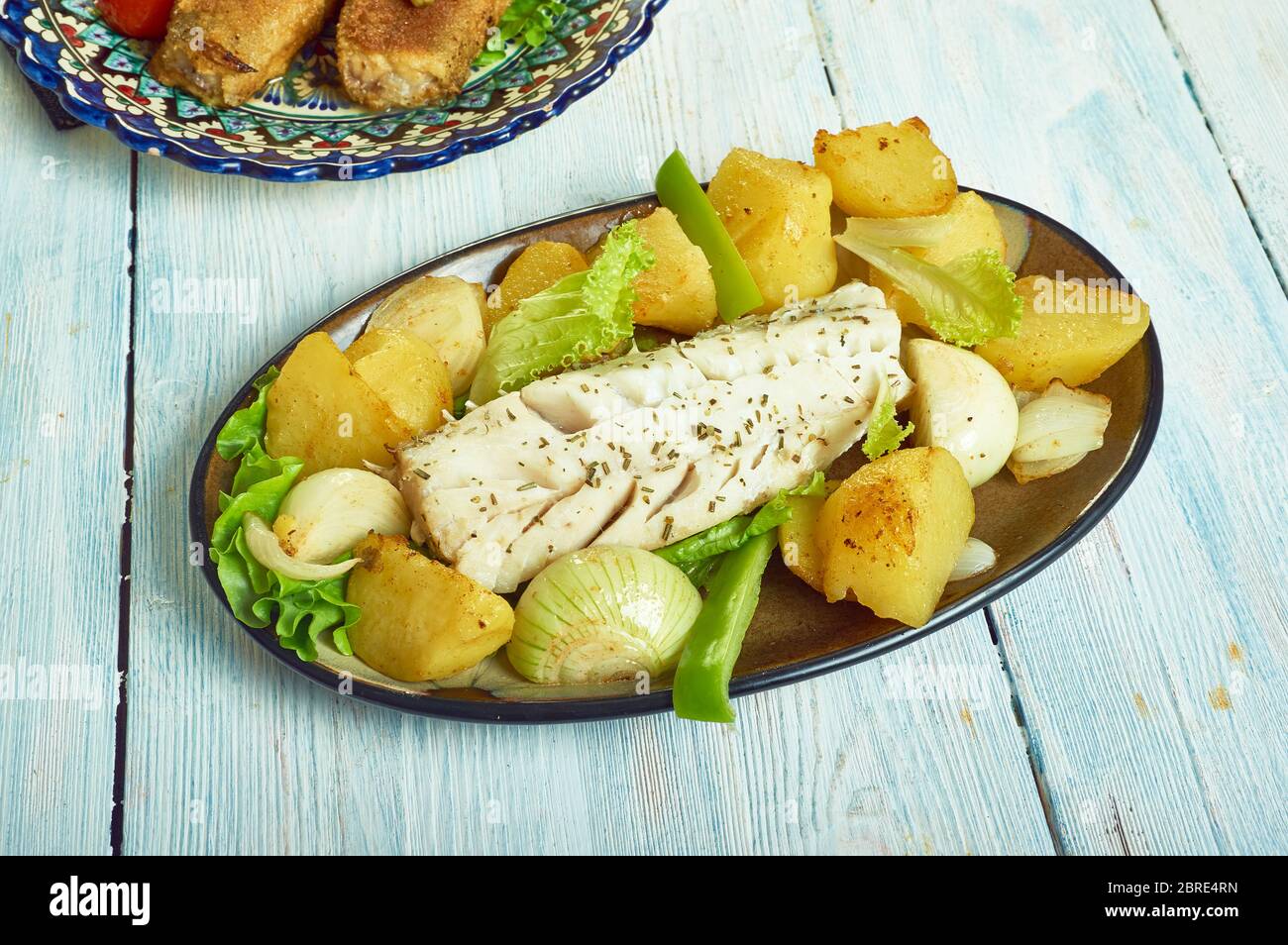 Sizzling cod, Baked fish fillet with potatoes peppers Stock Photo - Alamy