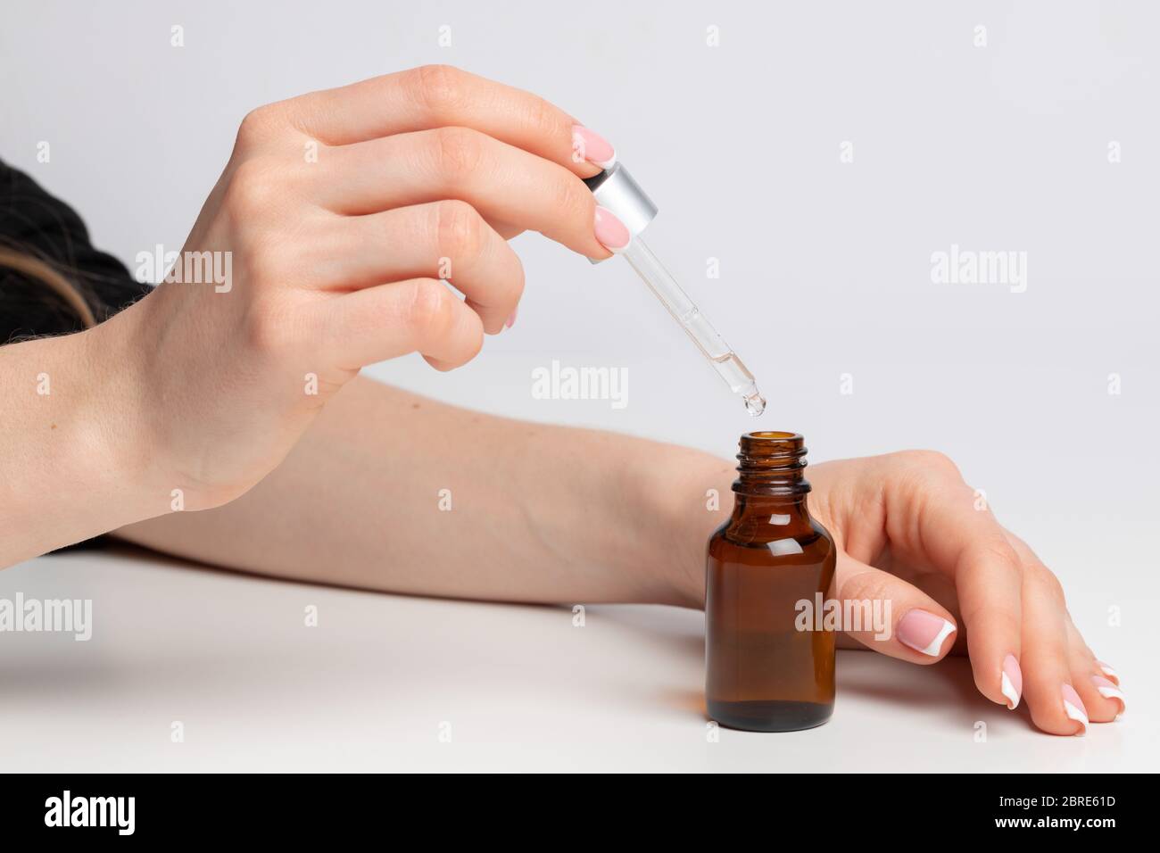 Female hand applying skincare product with pipette Stock Photo - Alamy