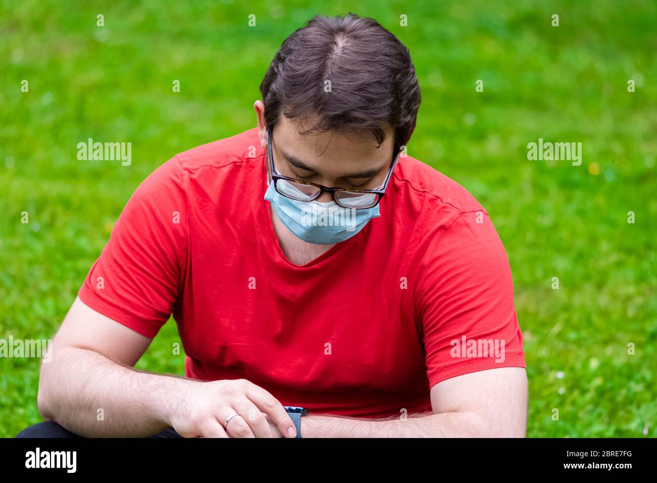 Man wearing face mask watching the smart watch after exercises Stock ...
