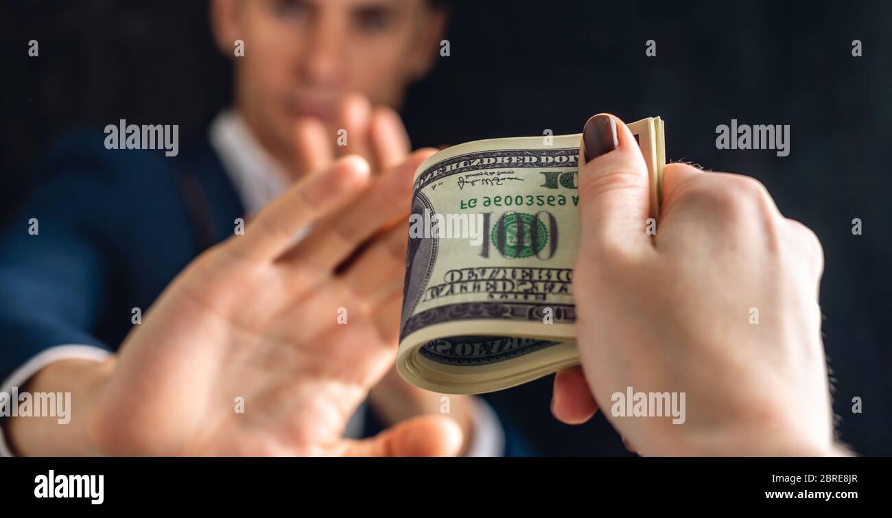 A man businessman in a suit refuses of money that is held in the hands ...