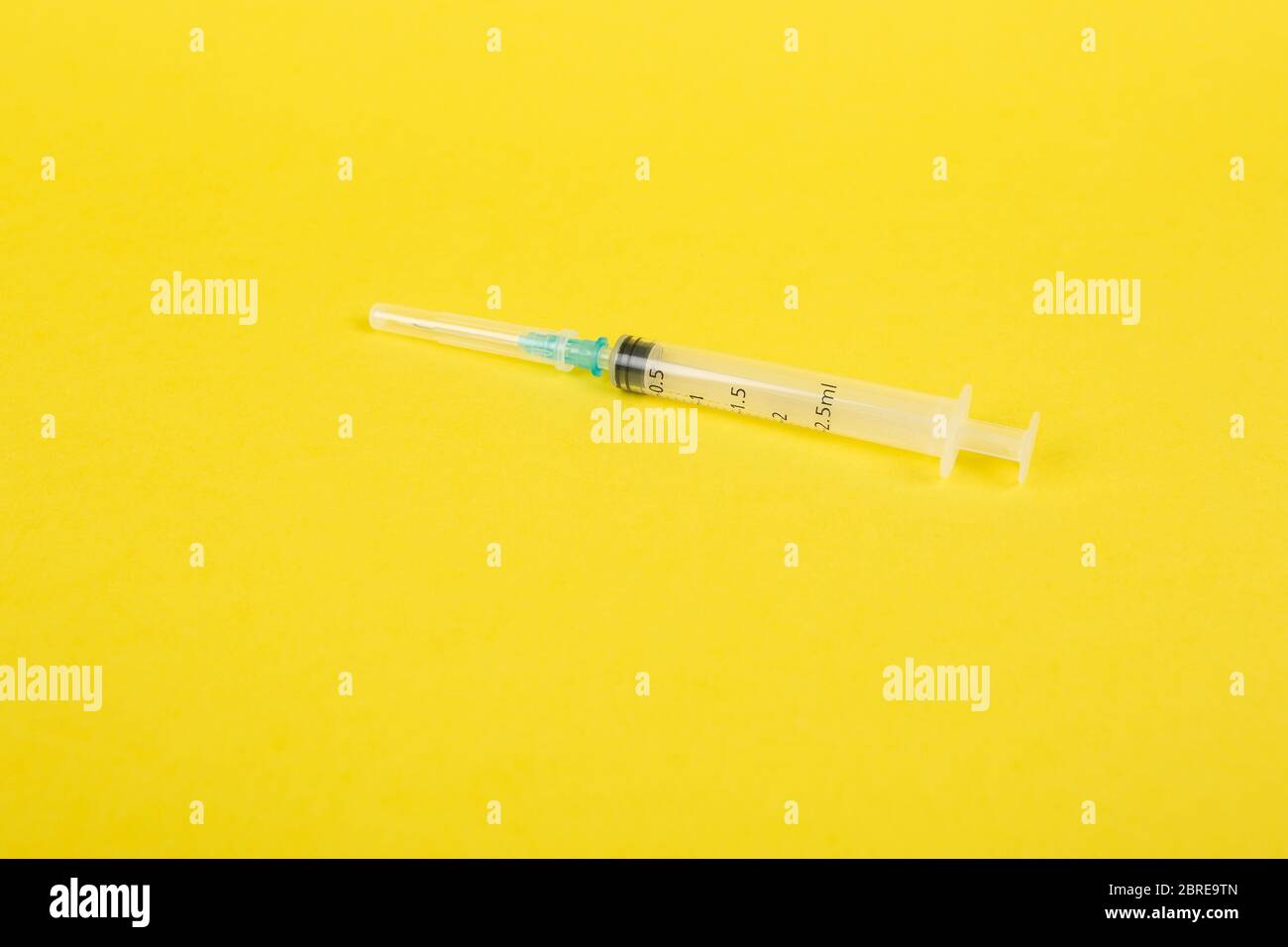 syringe for injection on yellow background Stock Photo - Alamy