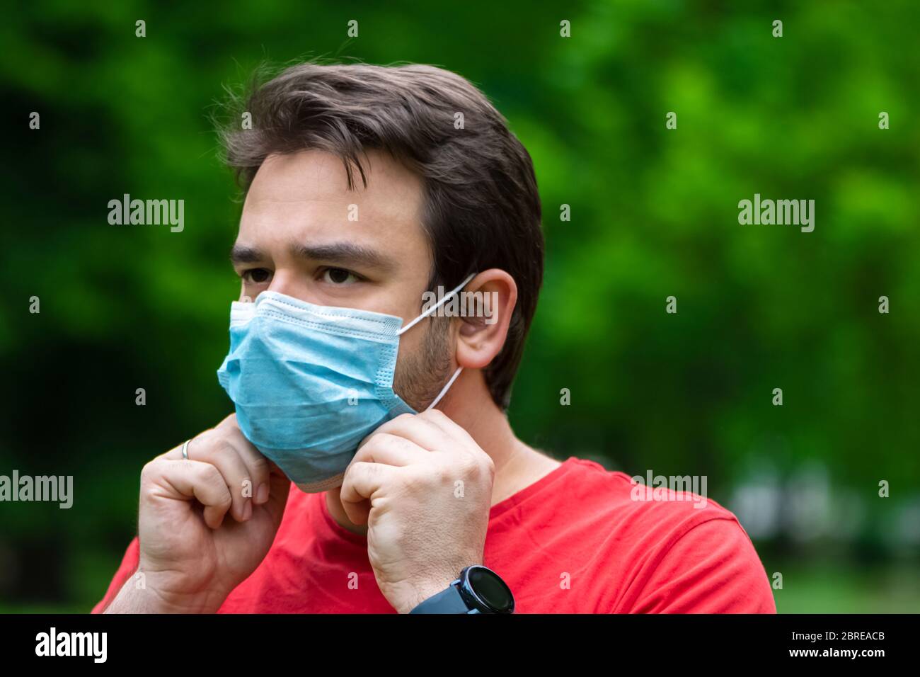 Man wearing surgical mask while he is outside Stock Photo - Alamy