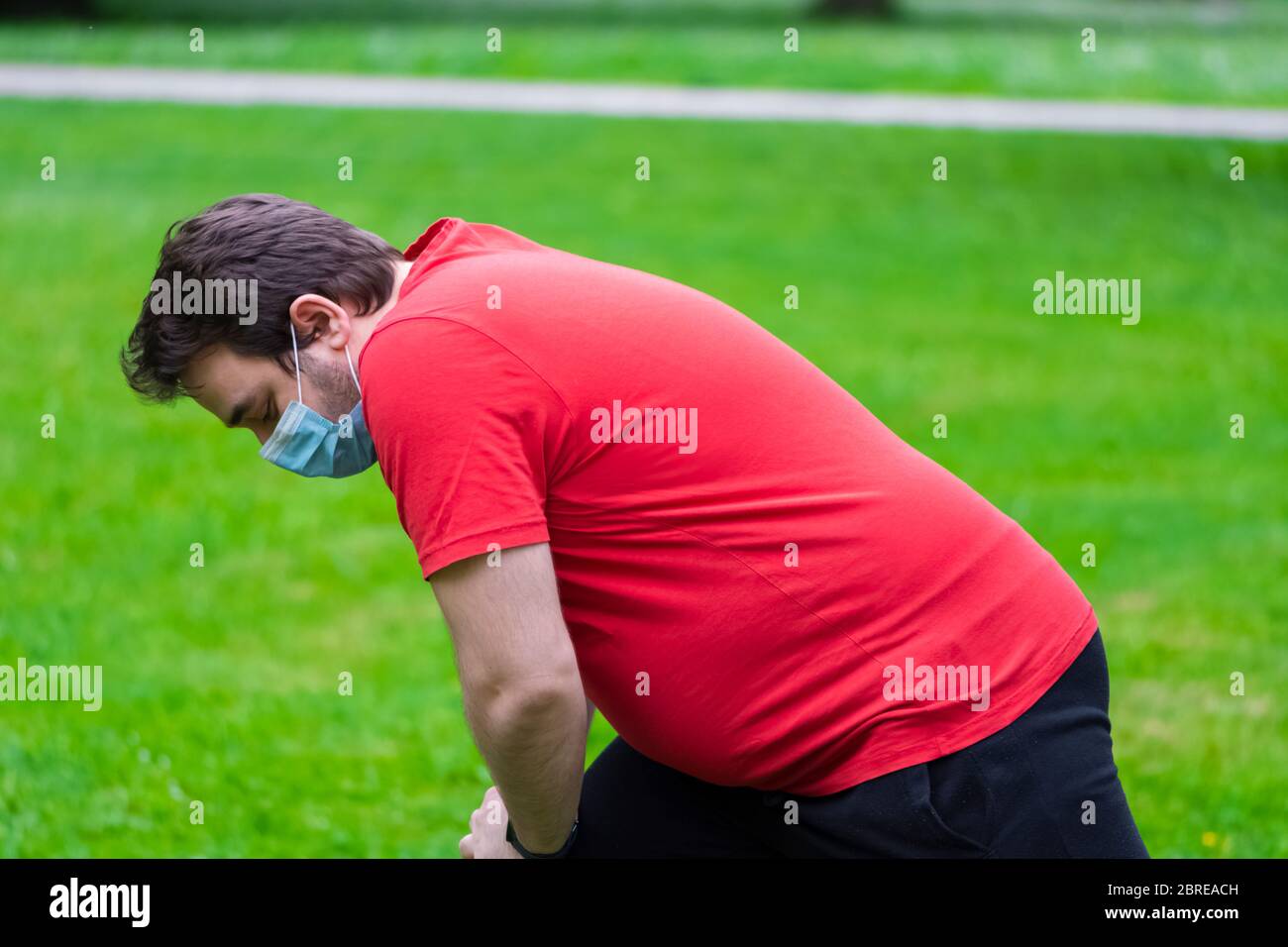 Fat man wearing face mask doing exercises after quarantine Stock Photo ...