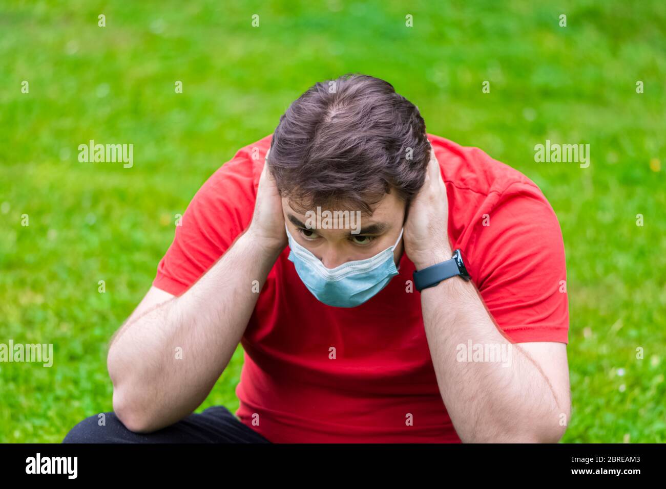 Fat man wearing face mask sitting on the grass Stock Photo - Alamy