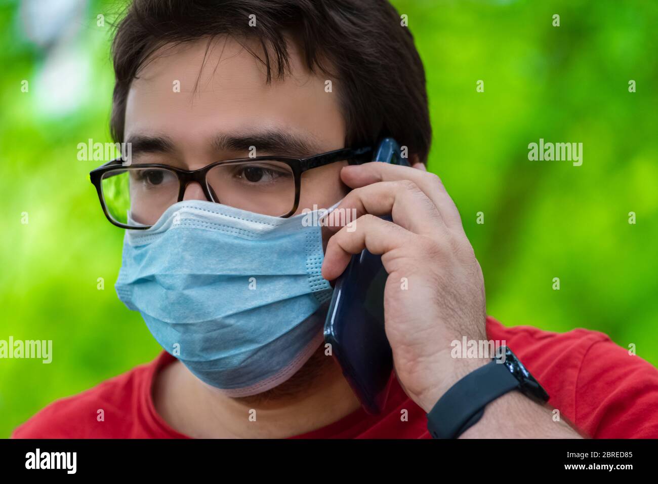 Man wearing face mask talking on the mobile phone Stock Photo - Alamy