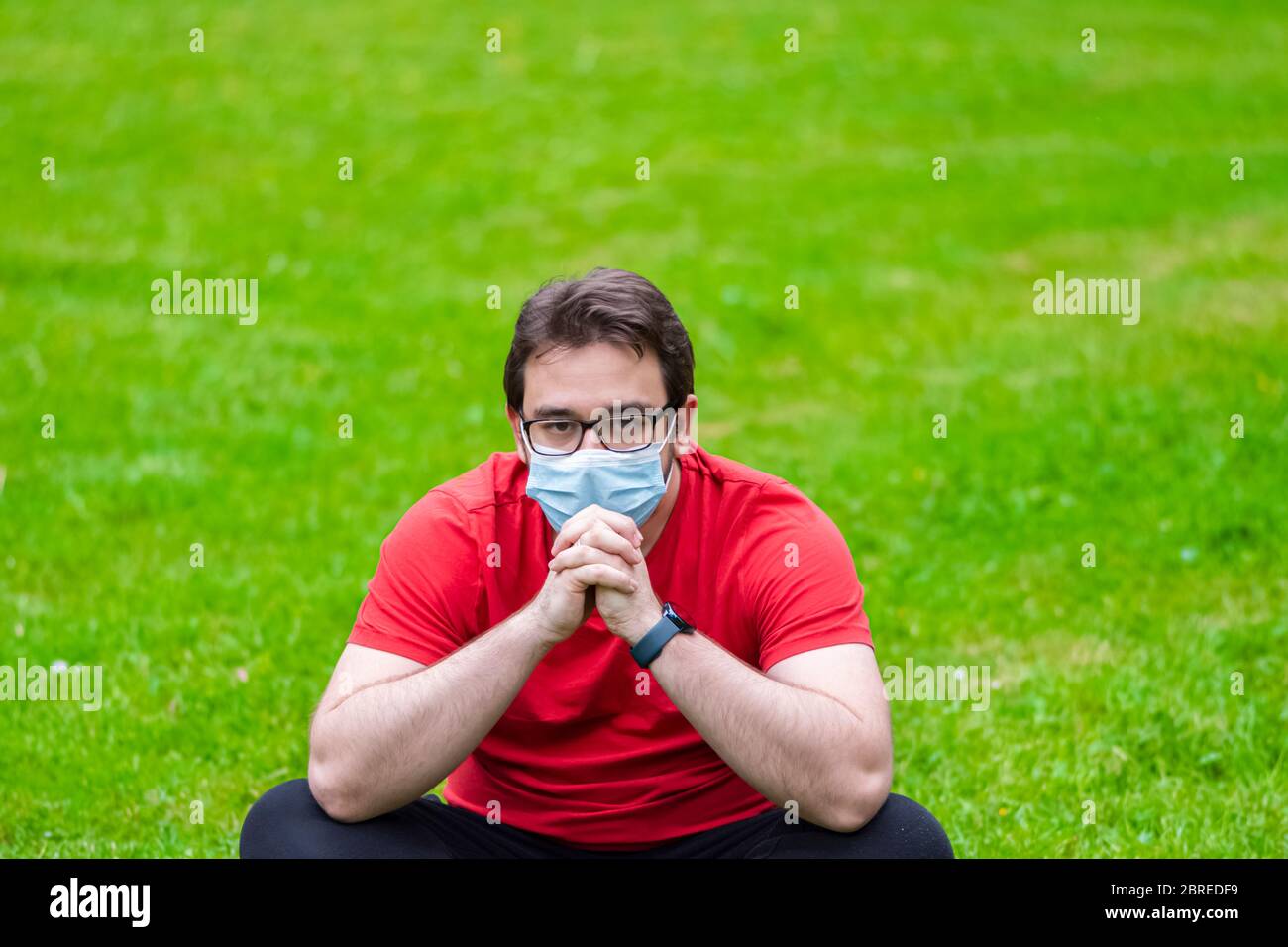 Fat man wearing face mask sitting on the grass Stock Photo - Alamy