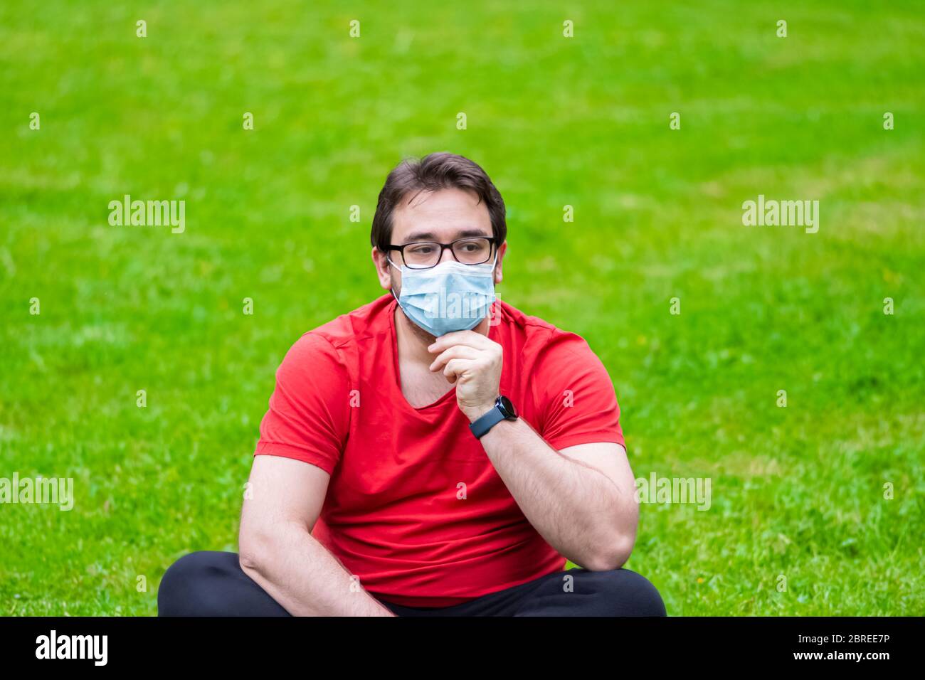 Fat man wearing face mask sitting on the grass Stock Photo - Alamy