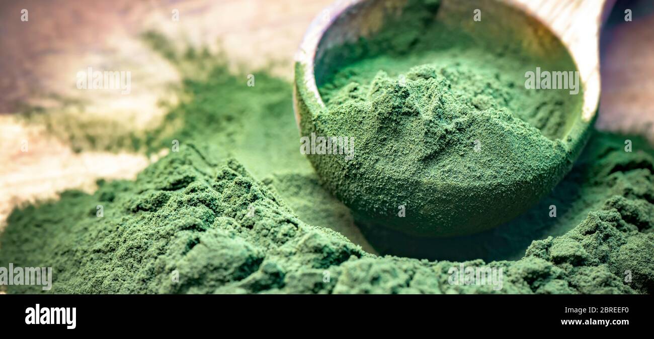 Green algae in powder - chlorella, spirulina in wooden spoon on wooden ...