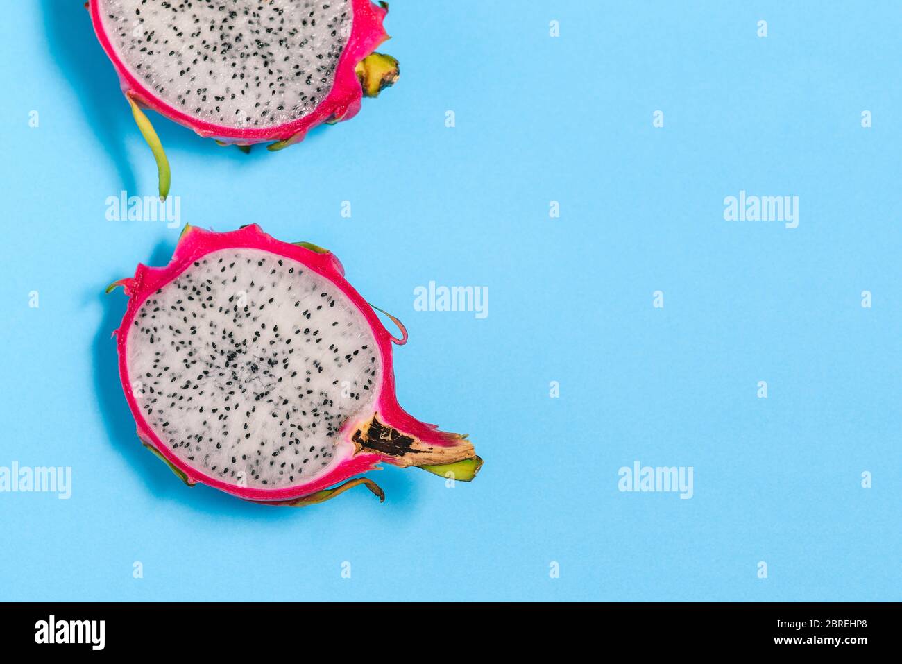 Slices of Pitaya or pitahaya close-up on a blue background with a copy ...
