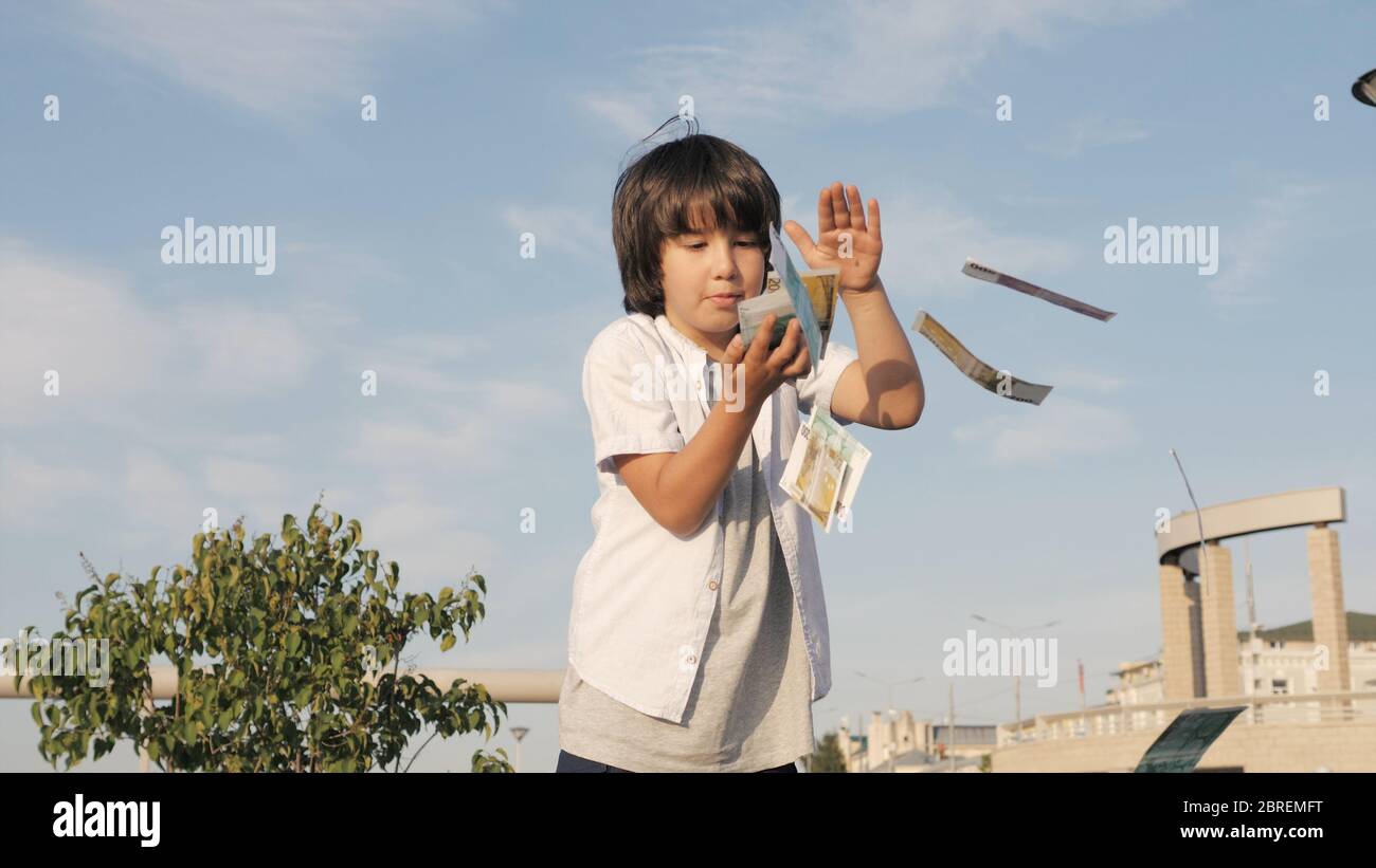 Little cute kid throwing euro banknotes Stock Photo - Alamy