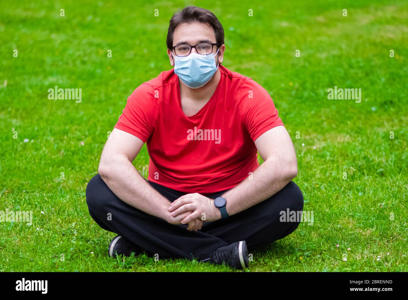 Fat man wearing face mask sitting on the grass Stock Photo - Alamy