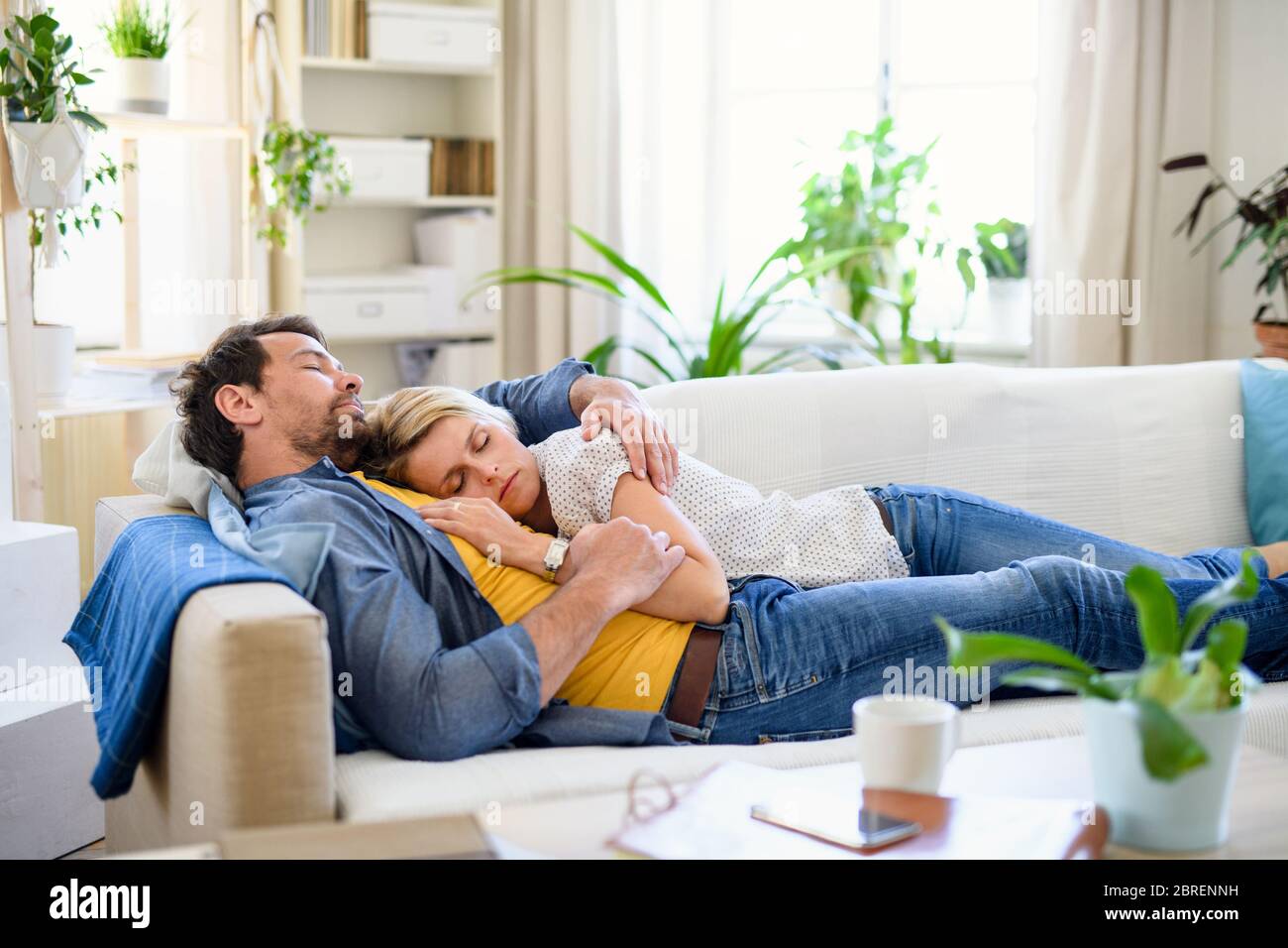 Happy couple in love on sofa indoors at home sleeping Stock Photo Alamy
