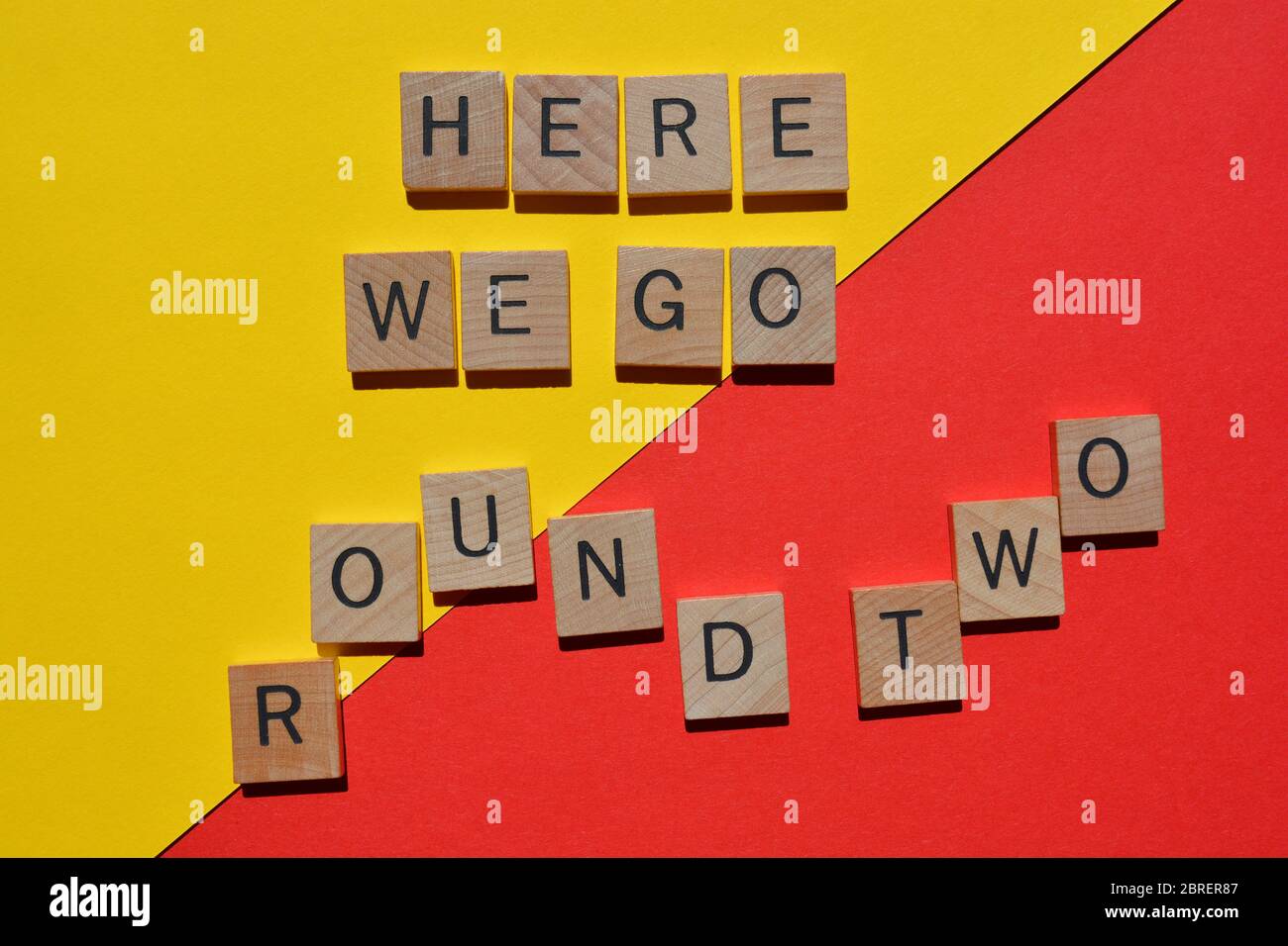 Here We Go, Round Two. Phrase in wooden alphabet letters on red and ...