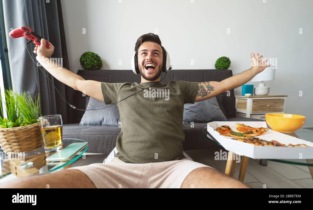 Happy man playing online video games - Young gamer having fun on new ...