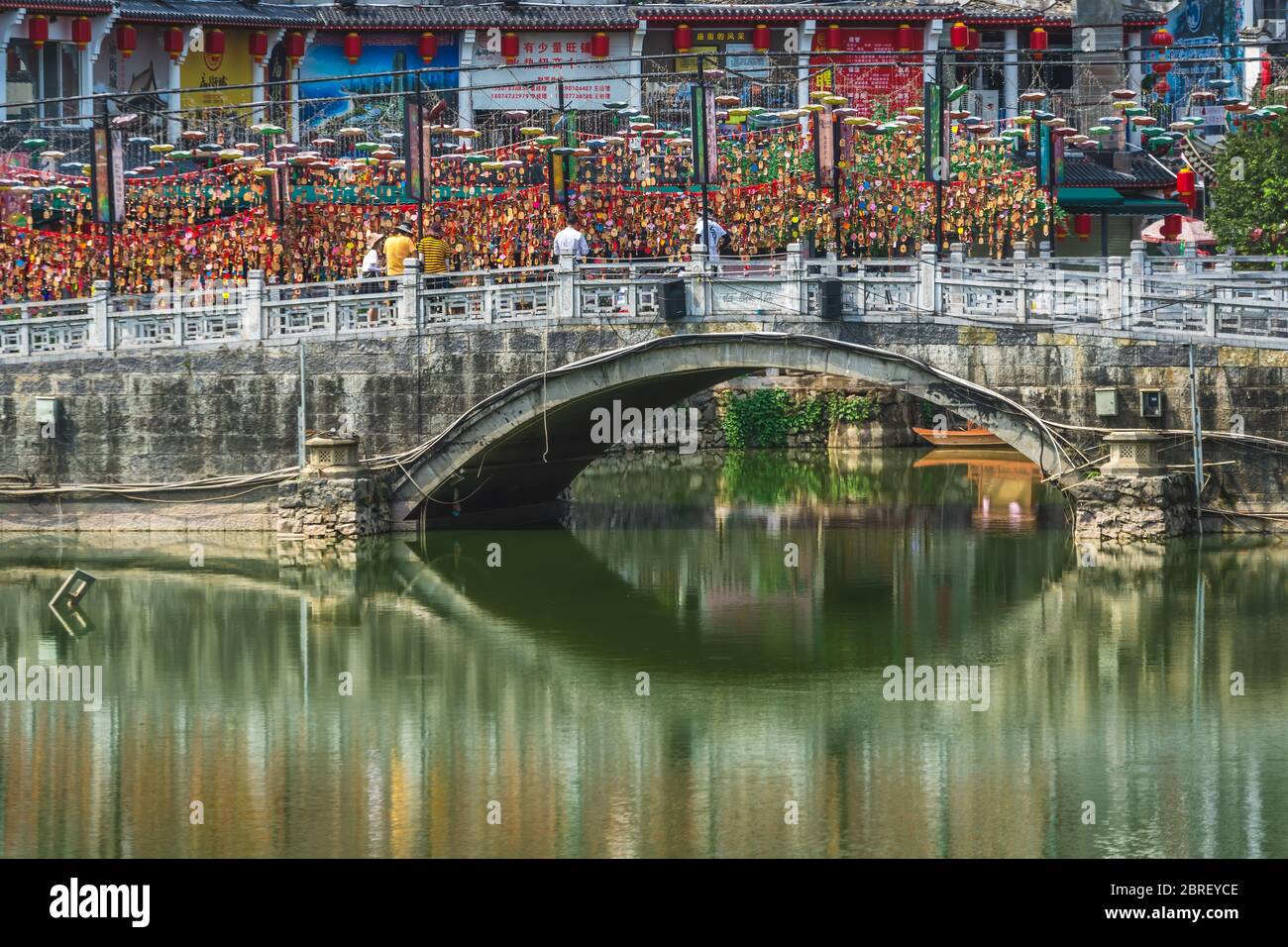 Yangshuo, China - August 2019 : Ancient arched bridge over the pond and ...