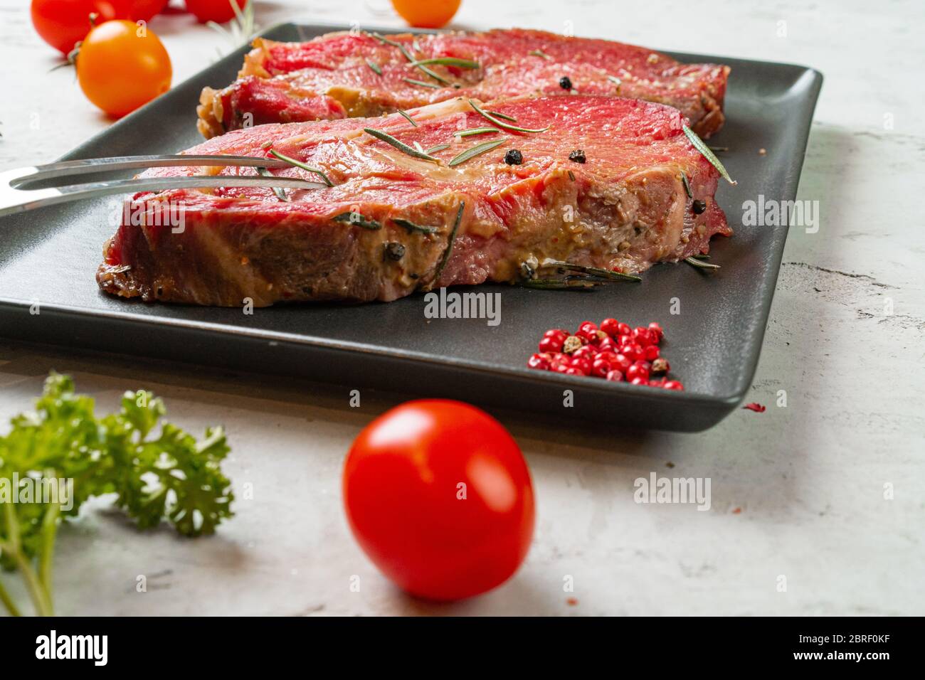 Marinated raw steaks on stone table with spices Stock Photo - Alamy