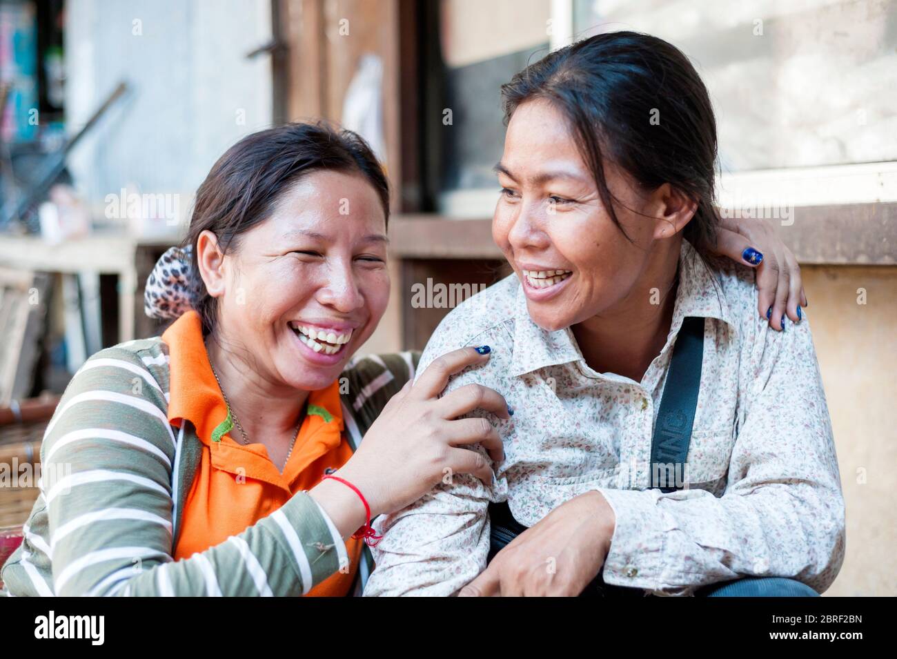 Two Cambodian sisters laughing together at Psar Nat Market, Battambang ...