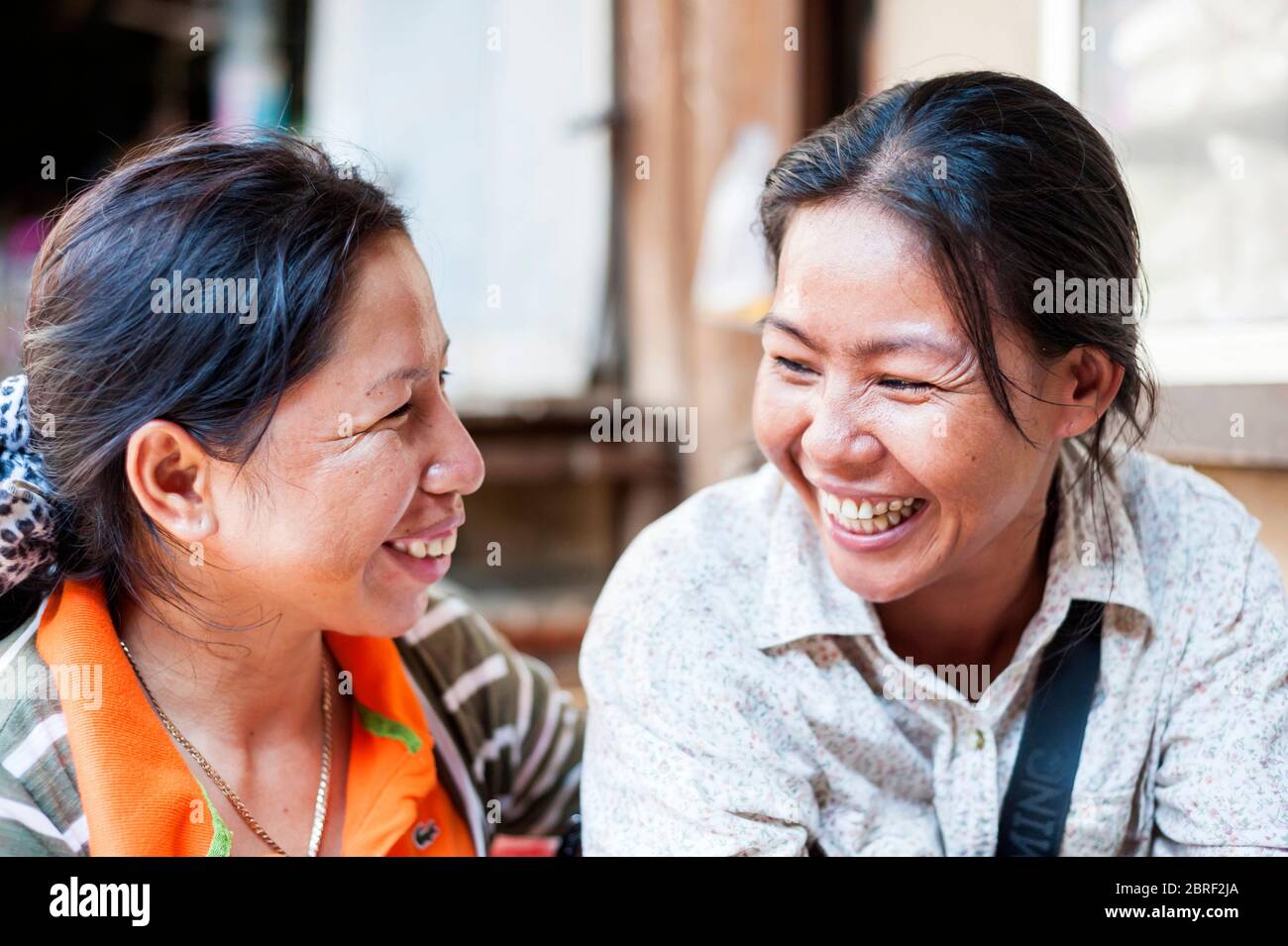 Two Cambodian sisters laughing together at Psar Nat Market, Battambang ...