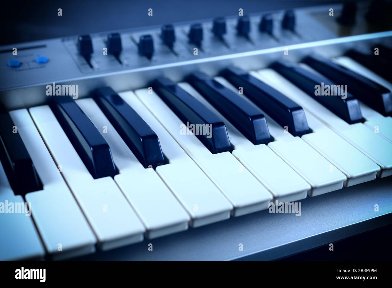 Musical midi keyboard, tinted in blue, vignetting Stock Photo - Alamy