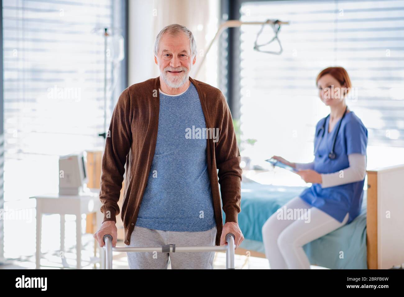 Female doctor and senior patient with walking frame in hospital Stock ...