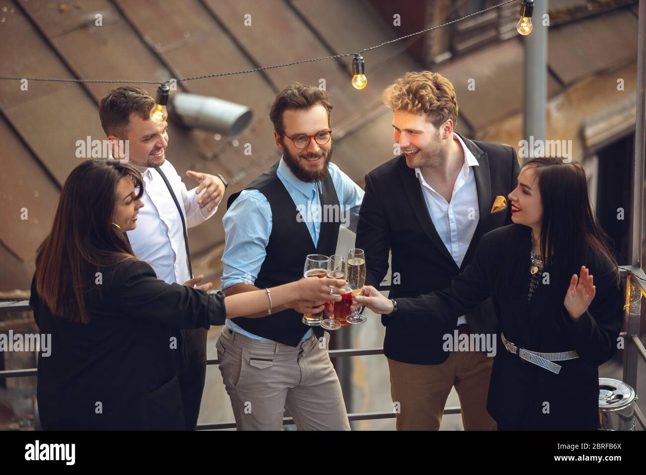 Cheers. Young people celebrating, look happy, have party at office or ...
