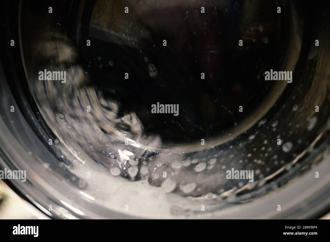 Working washing machine with various clothes Stock Photo - Alamy